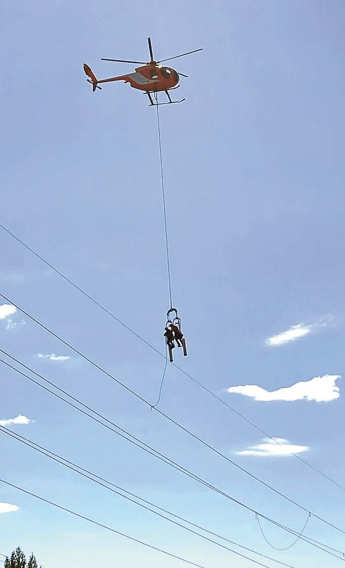 Not afraid of heights: Linemen dangling from helicopter repair power ...